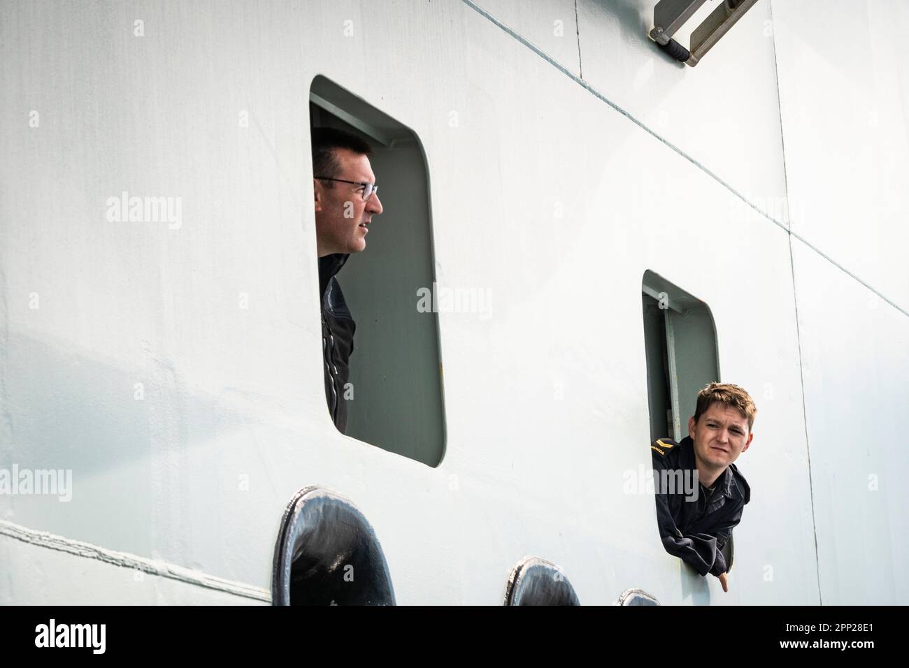 Crew members onboard HMCS Margaret Brooke stand at the rail watching ...