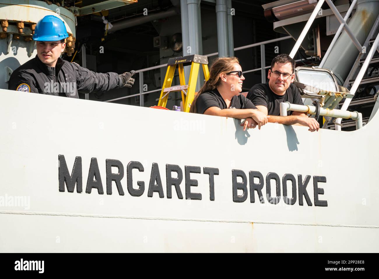 Crew members onboard HMCS Margaret Brooke stand at the rail watching ...