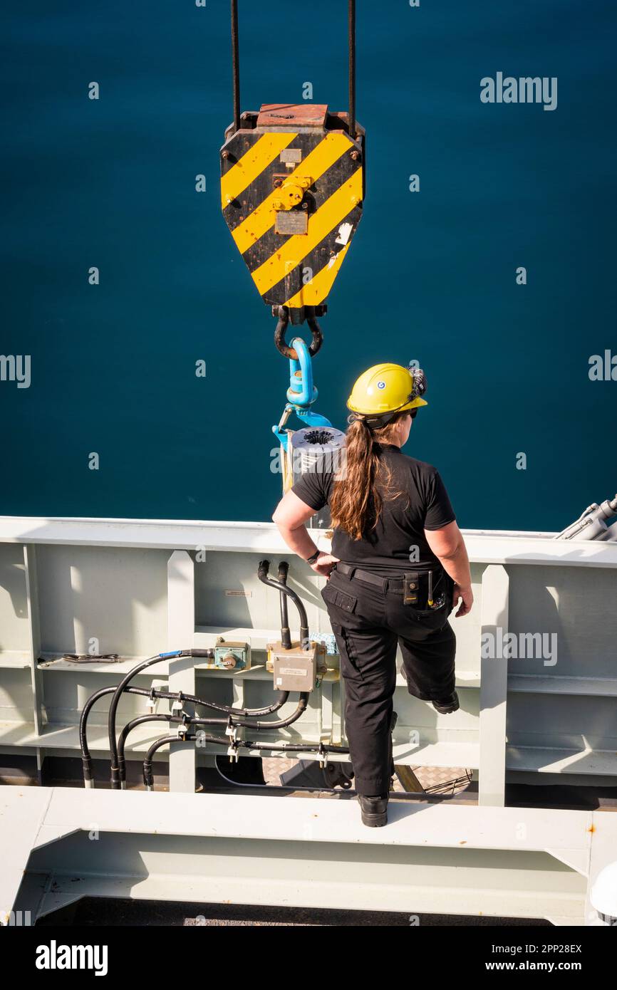 Sailors use the hydraulic crane at the stern of HMCS Margaret Brooke to ...