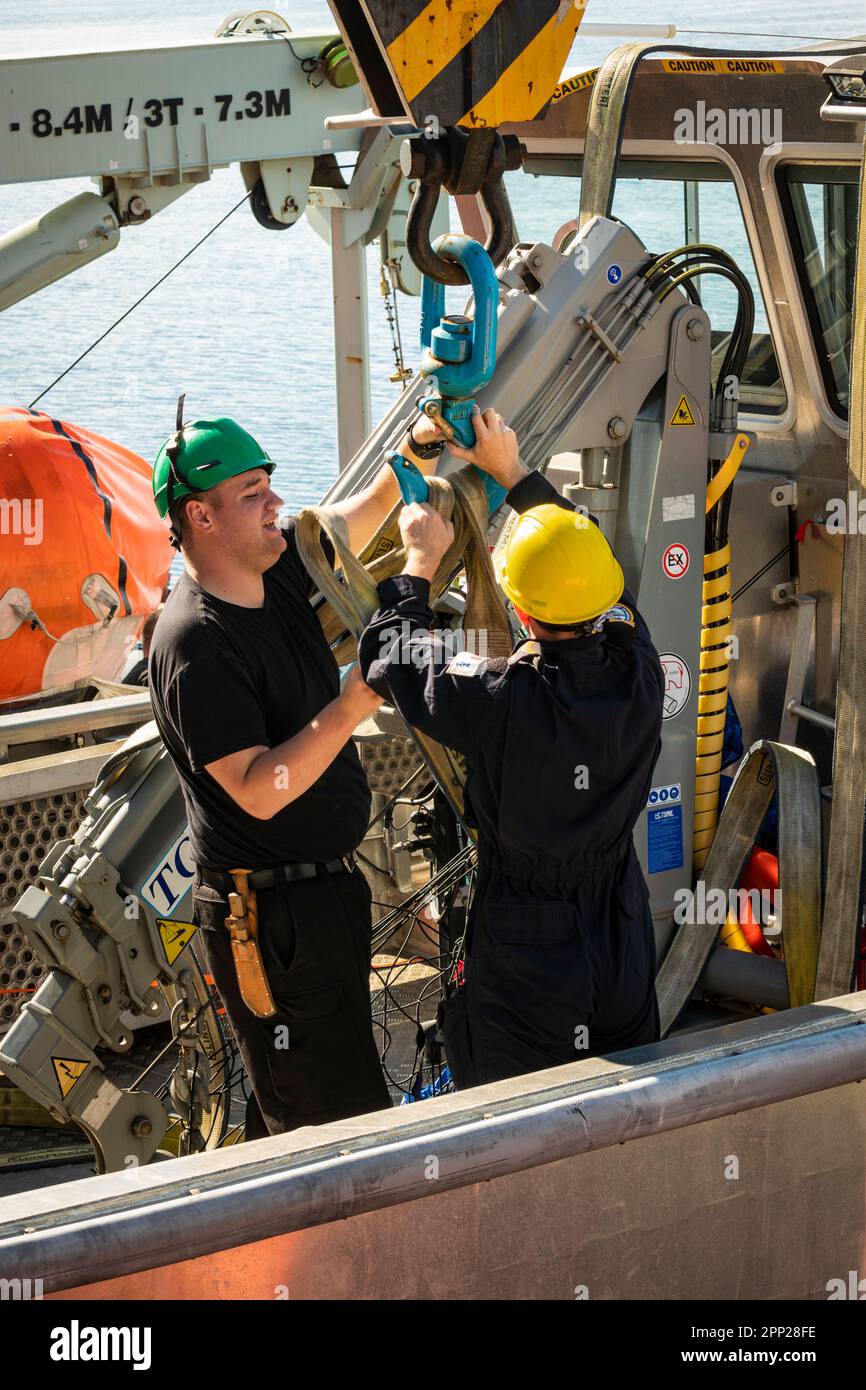 Sailors use the hydraulic crane at the stern of HMCS Margaret Brooke to ...