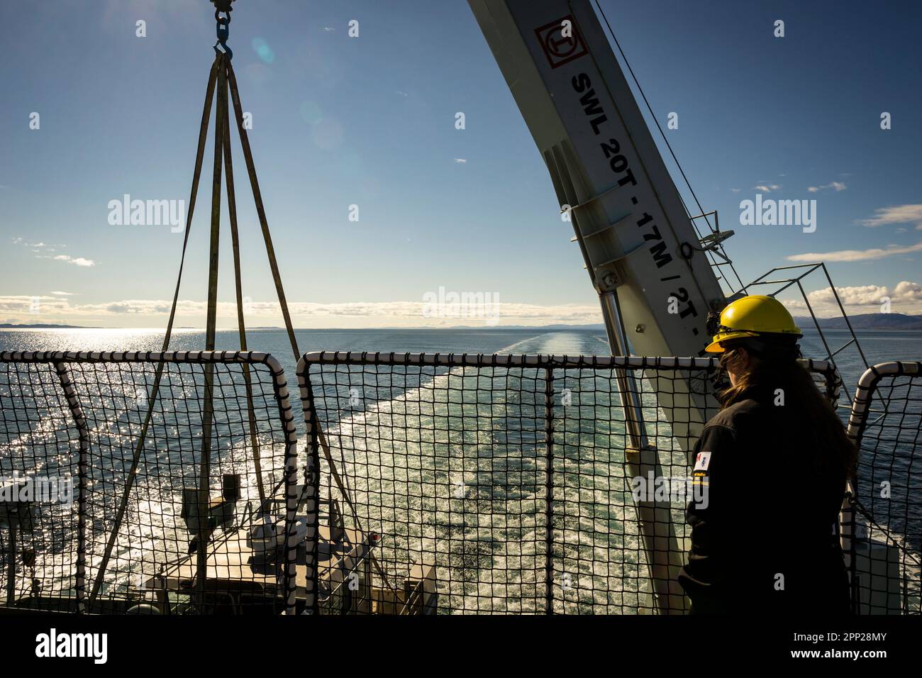Sailors use the hydraulic crane at the stern of HMCS Margaret Brooke to ...