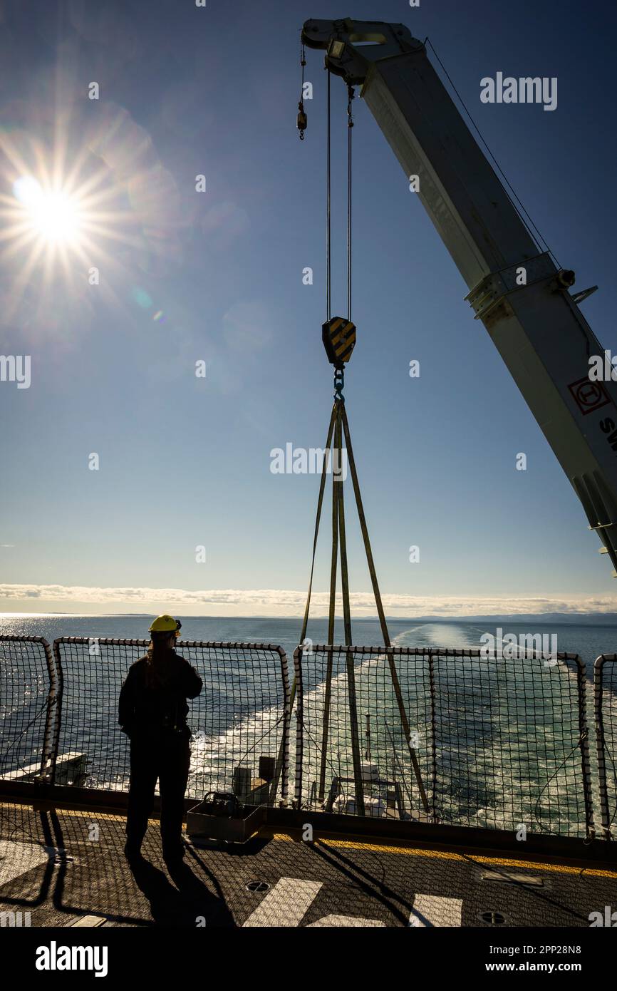 Sailors use the hydraulic crane at the stern of HMCS Margaret Brooke to ...