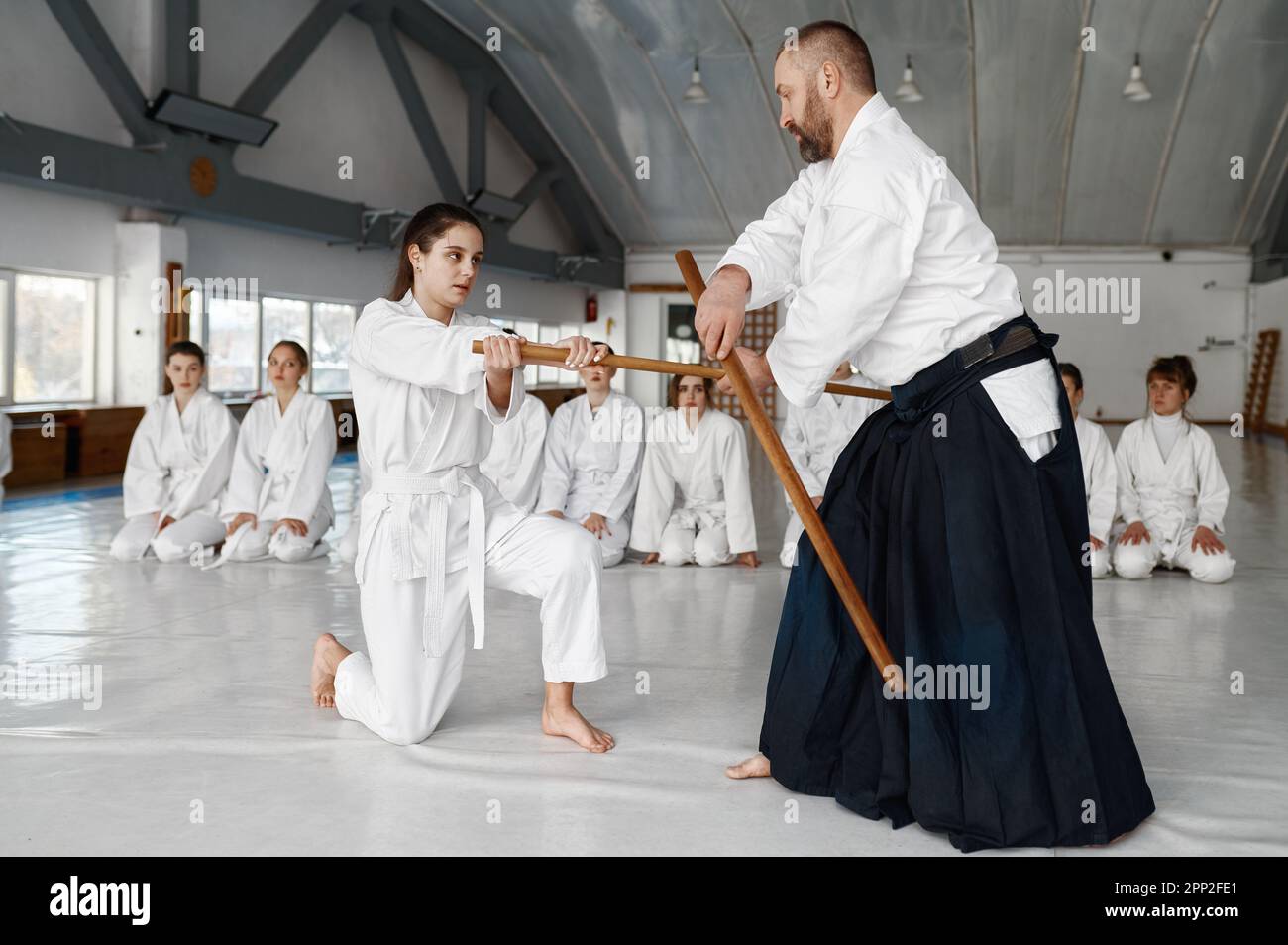 Sensei with young female student fighting with wooden sword Stock Photo ...