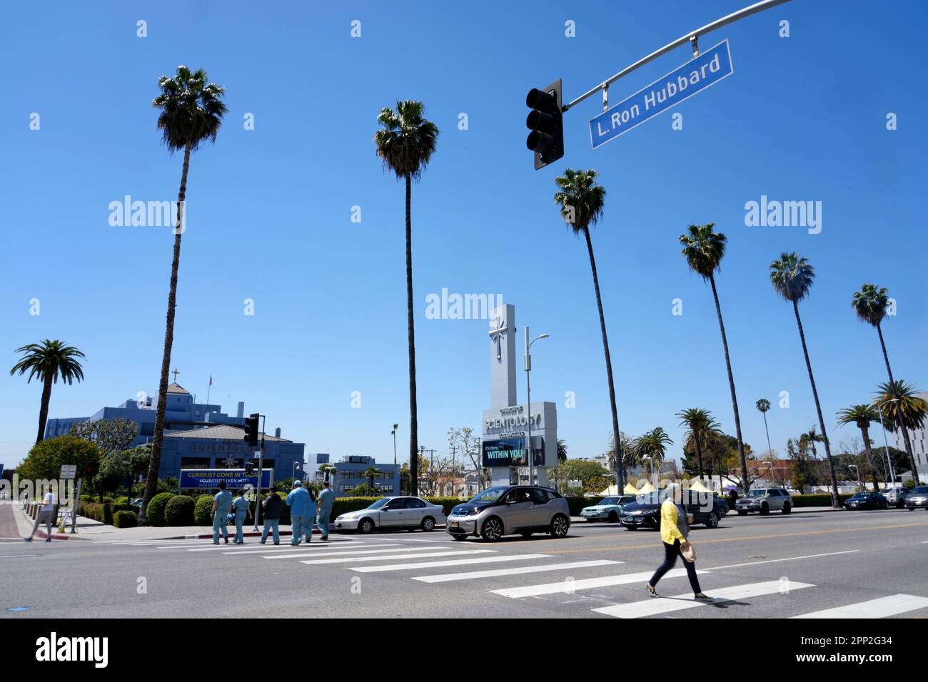 Pedestrians pass underneath a street sign for L Ron Hubbard Way in ...