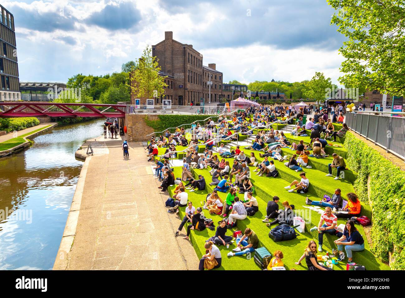 People sitting on steps in Granary Square looking over Regent's Canal ...