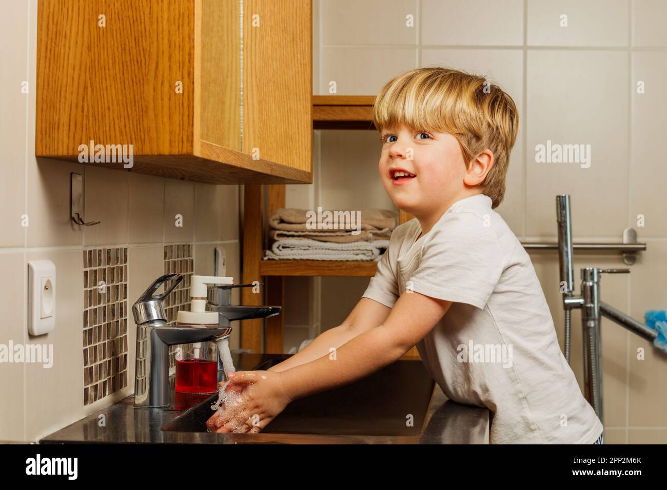 Cute boy wash hands under water in bathroom, smile Stock Photo - Alamy