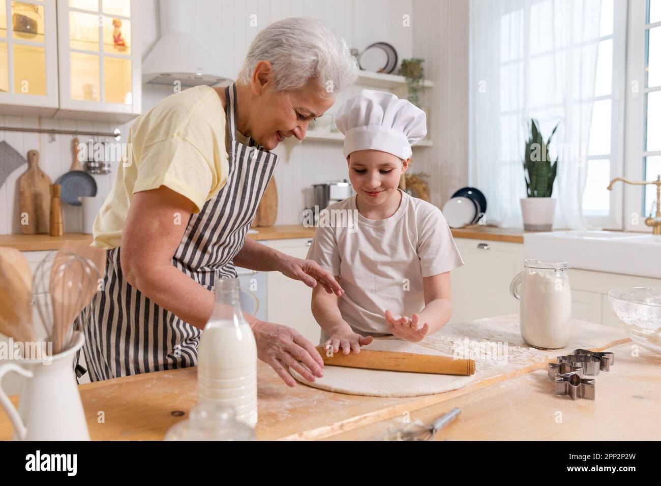 Happy family in kitchen. Grandmother and granddaughter child cook in ...