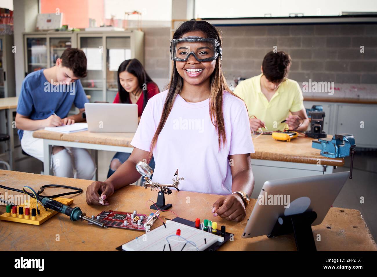 Looking at camera portrait of a young student wearing safety goggles in ...
