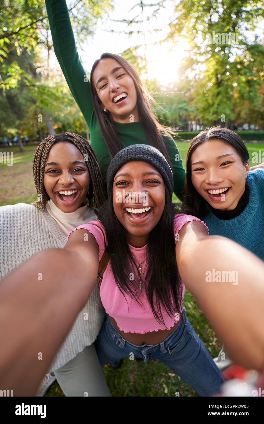 Vertical group girls having fun outdoors taking selfie. Smiling young ...