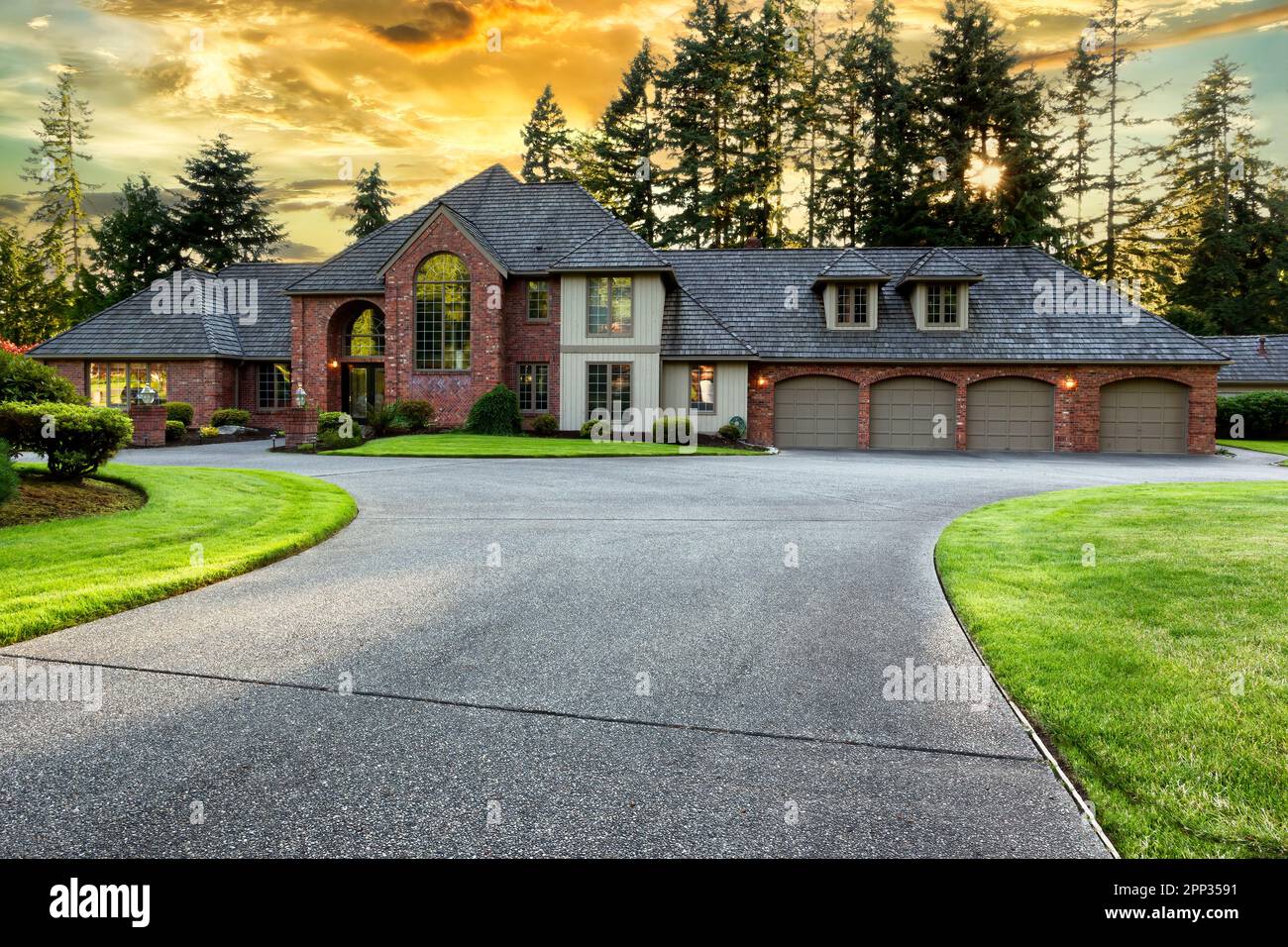 Beautiful luxury home exterior in early evening with golden sunset and ...