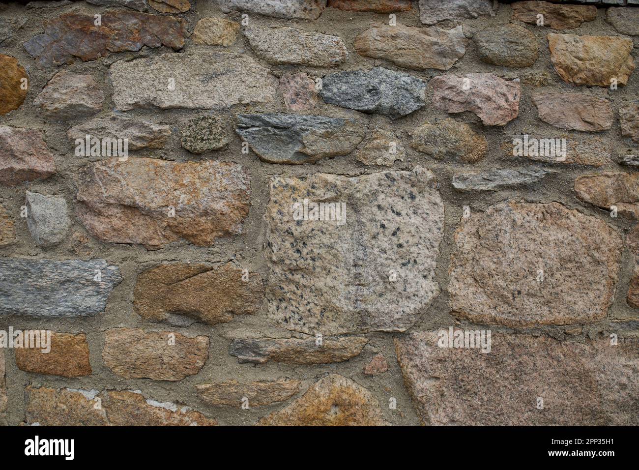 Rock wall with sandy and gray tones. Natural lighting on the building's ...