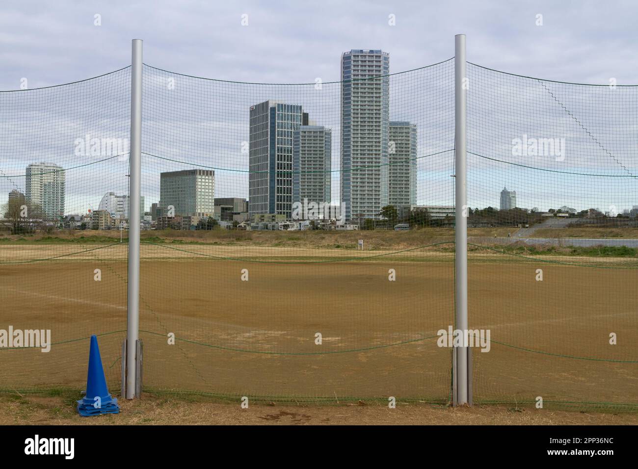 Tall buildings in Futako Tamagawa begind the fence of a riverside ...