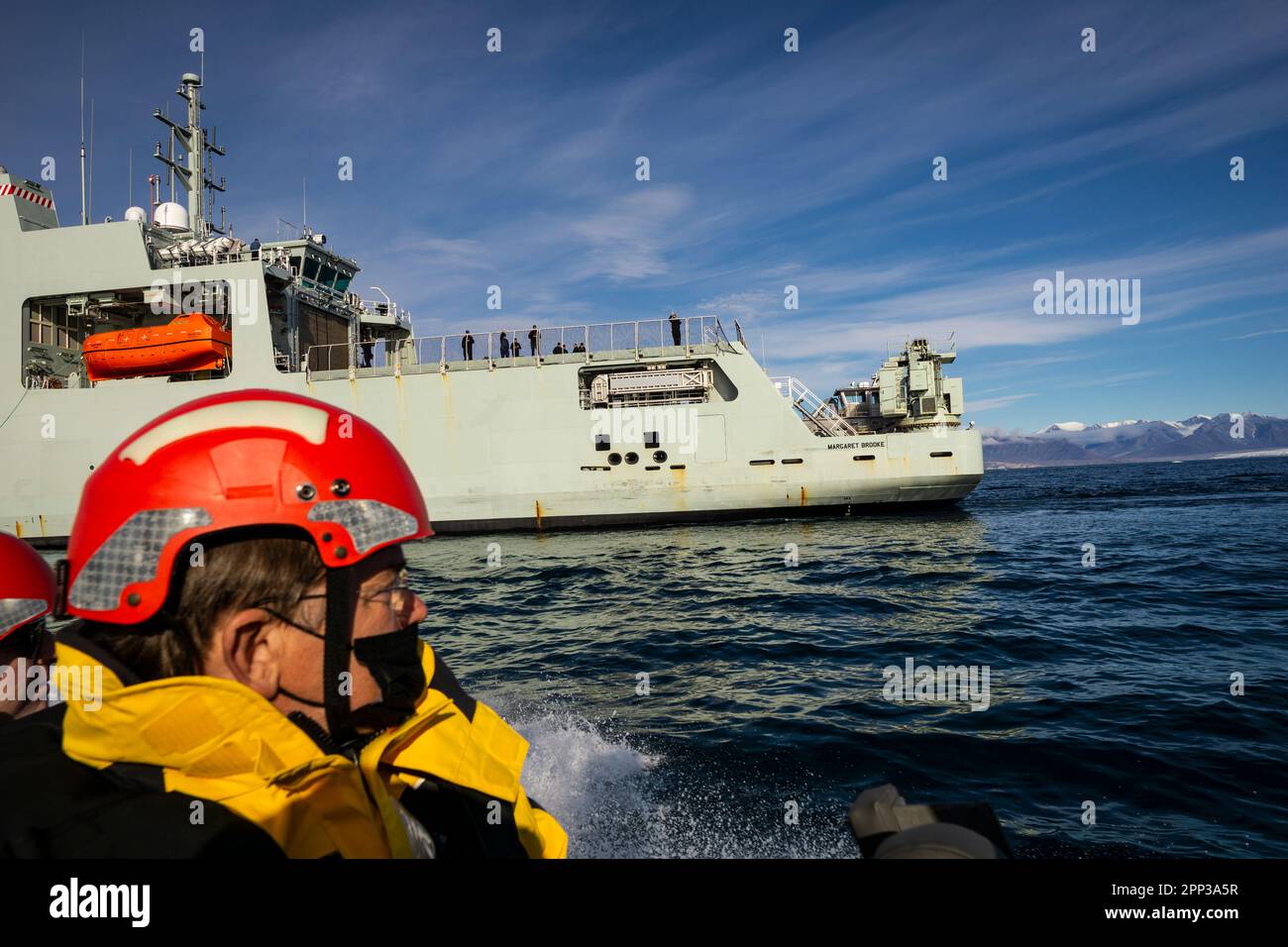 Crew member wearing helmet disembarks HMCS Margaret Brooke via small ...