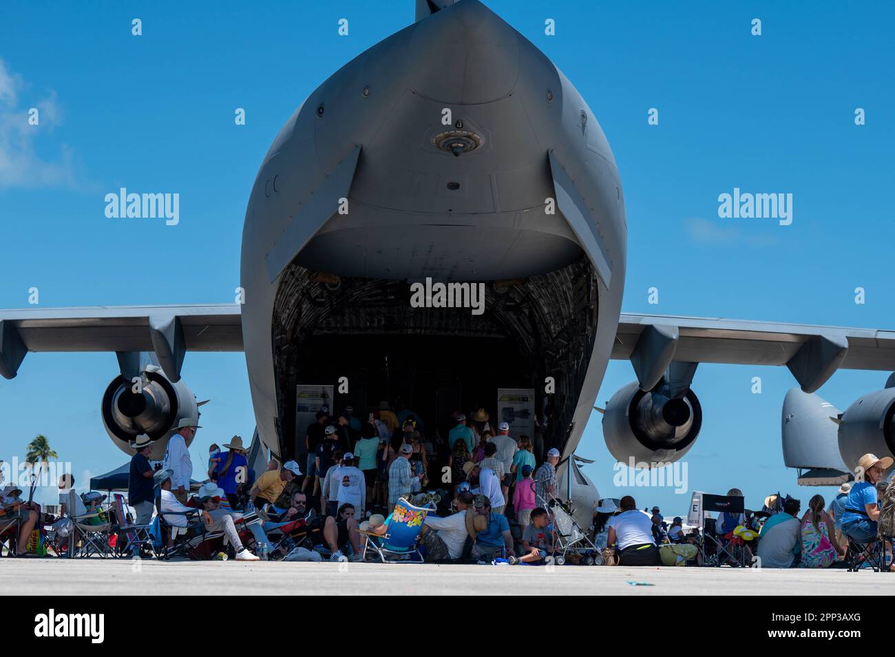 Visitors sit in the shade of a C-17 Globemaster III from the 315th ...