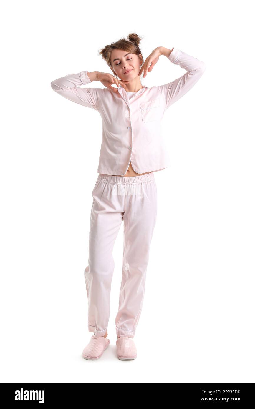 Sleepy young woman in pajamas on white background Stock Photo - Alamy