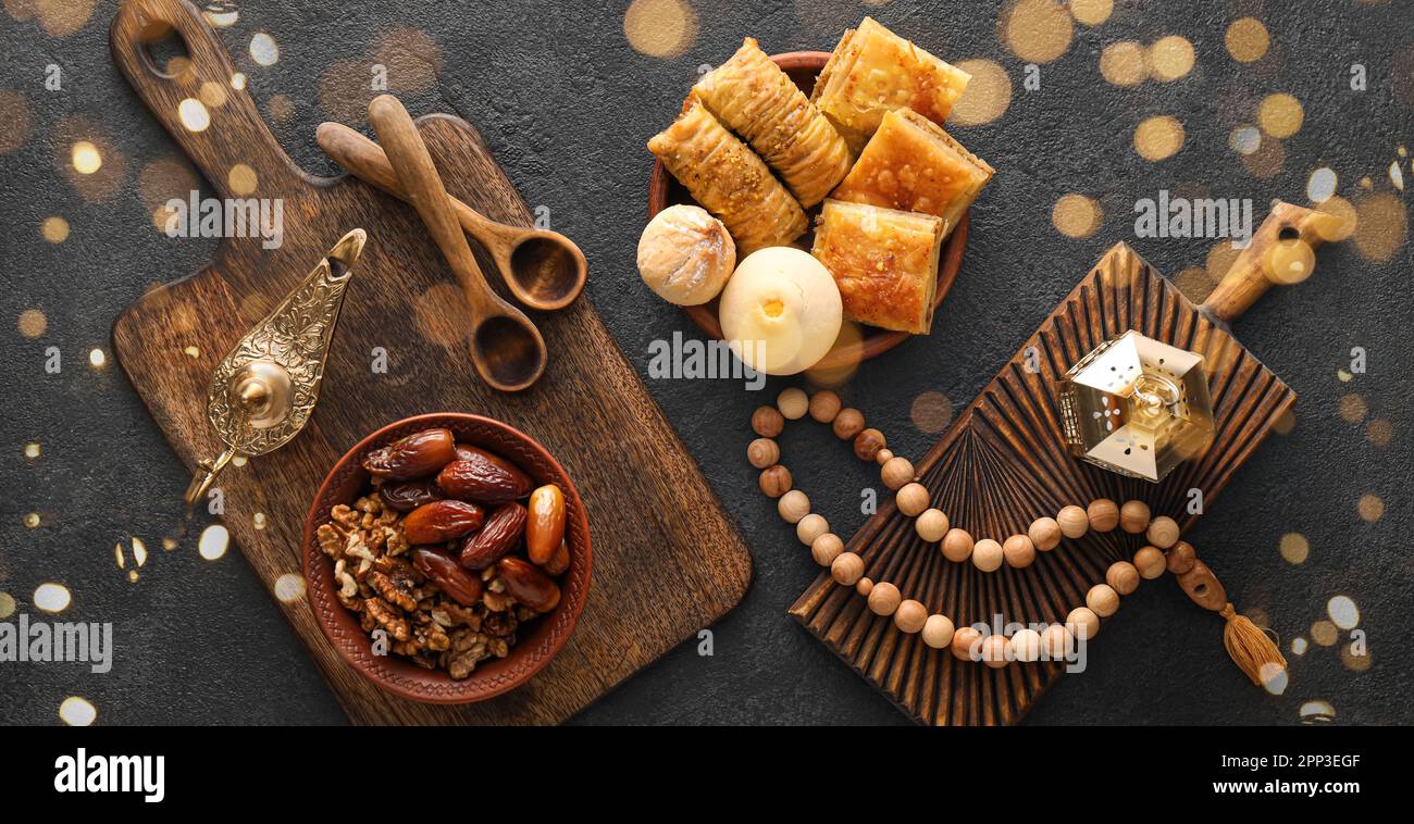 Tasty Eastern sweets with tasbih and Arabic lamps on dark background ...