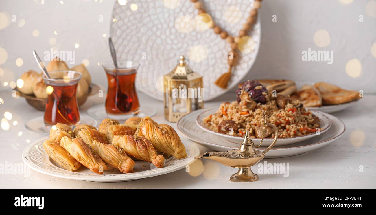 Traditional Eastern dishes with Aladdin lamp on light background Stock ...