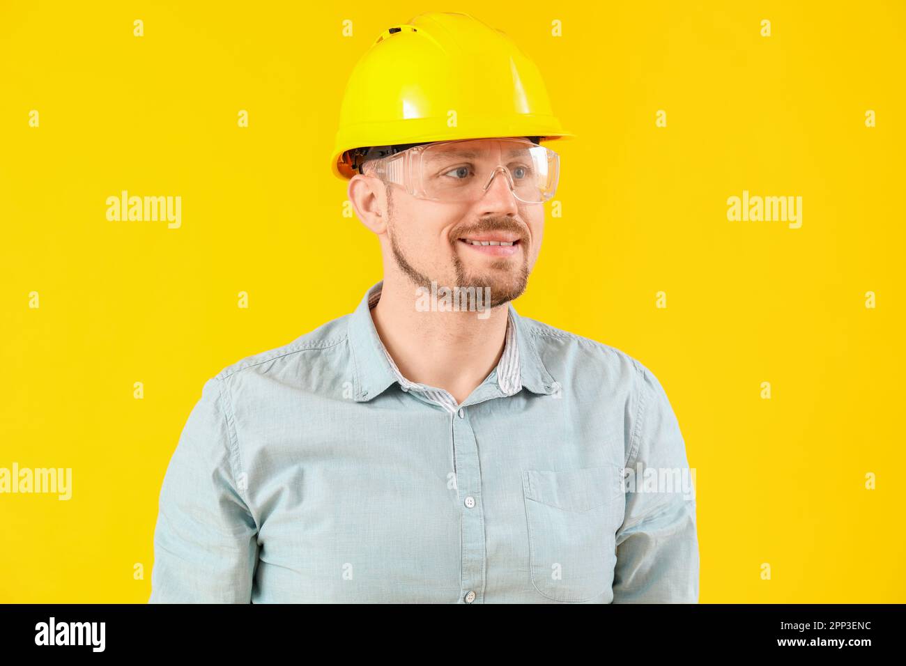 Male carpenter in safety goggles on yellow background Stock Photo - Alamy