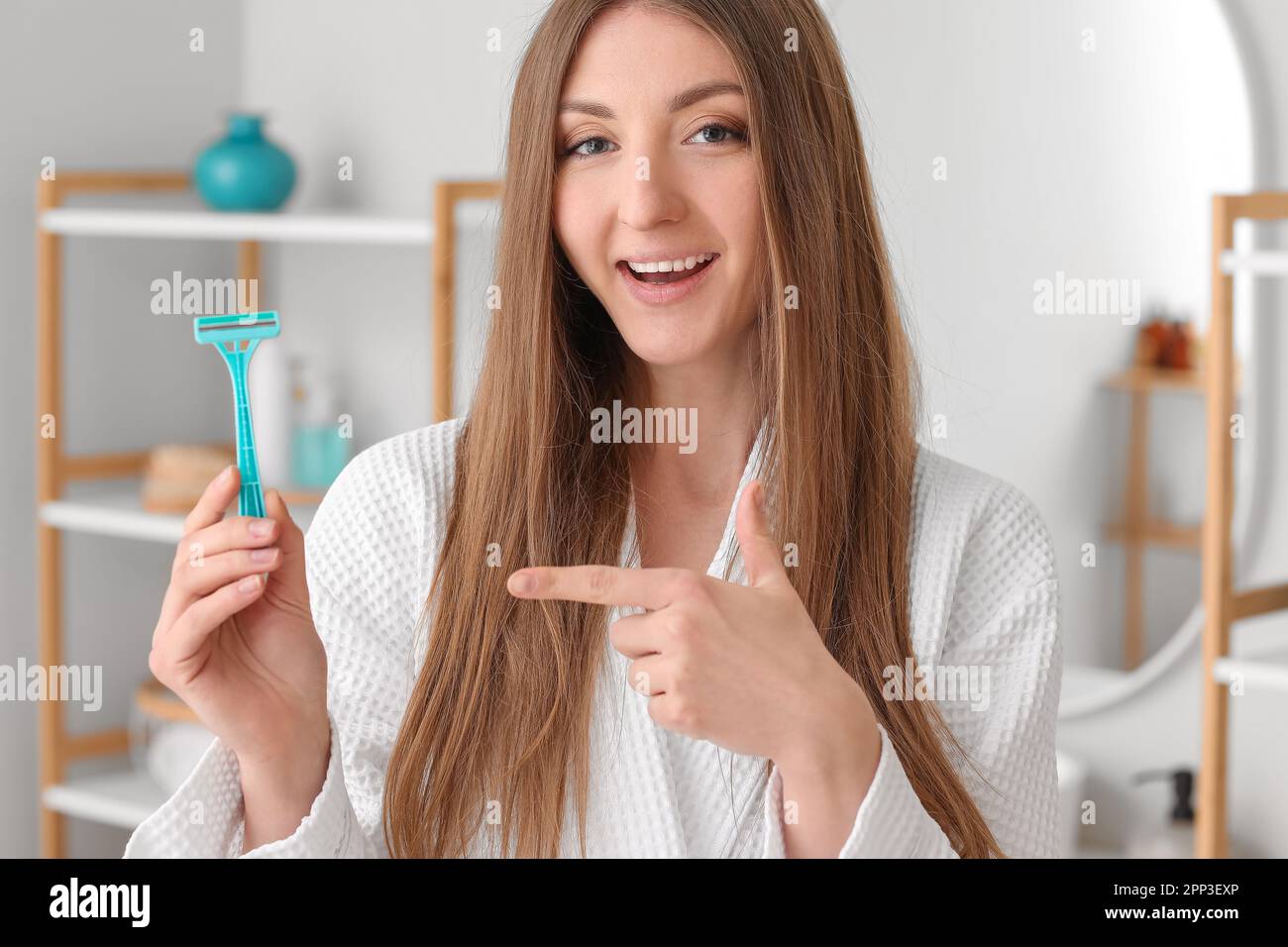 Pretty young woman with razor in bathroom Stock Photo - Alamy