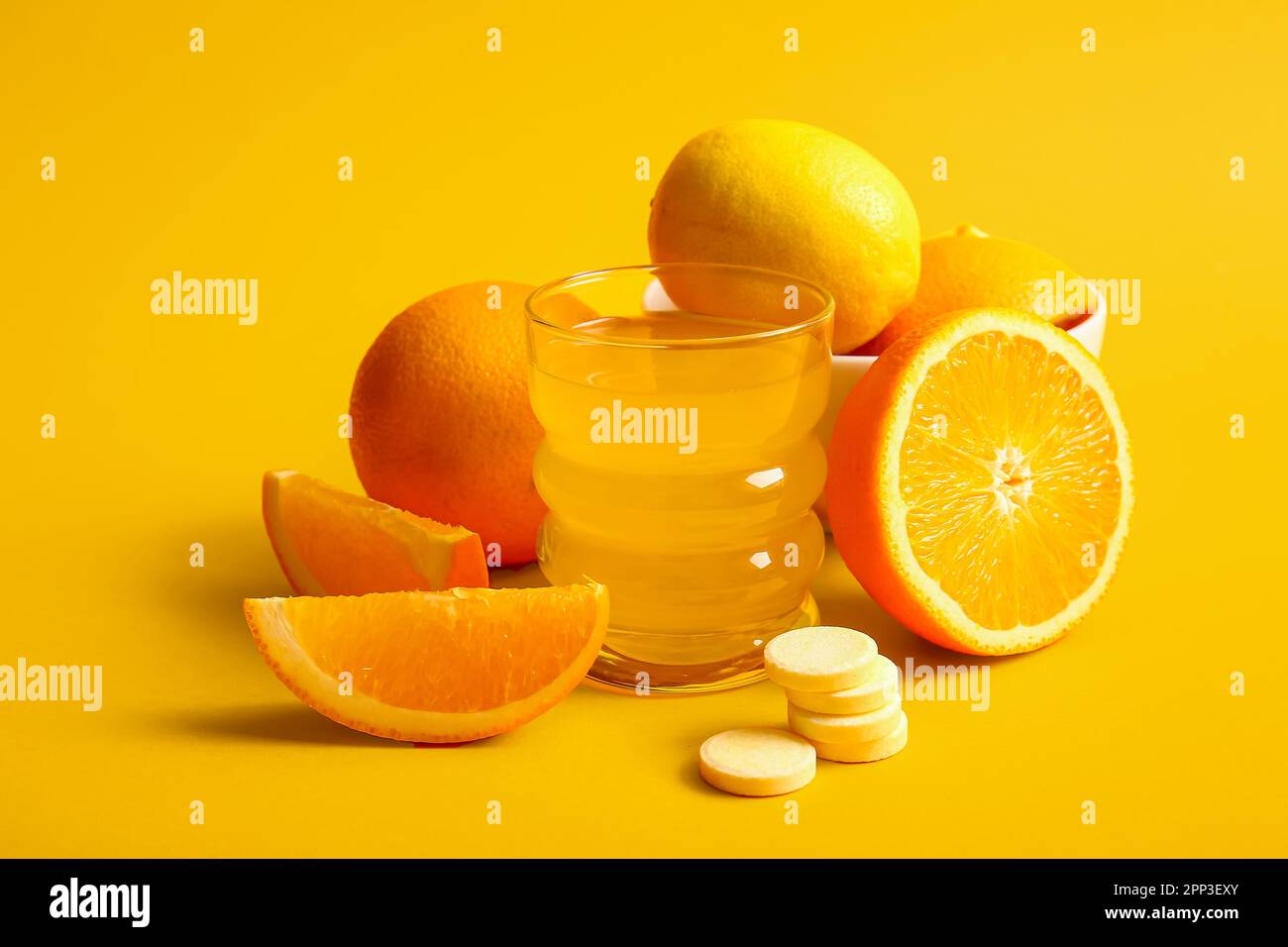 Glass of vitamin C effervescent tablet dissolved in water and fruits on ...