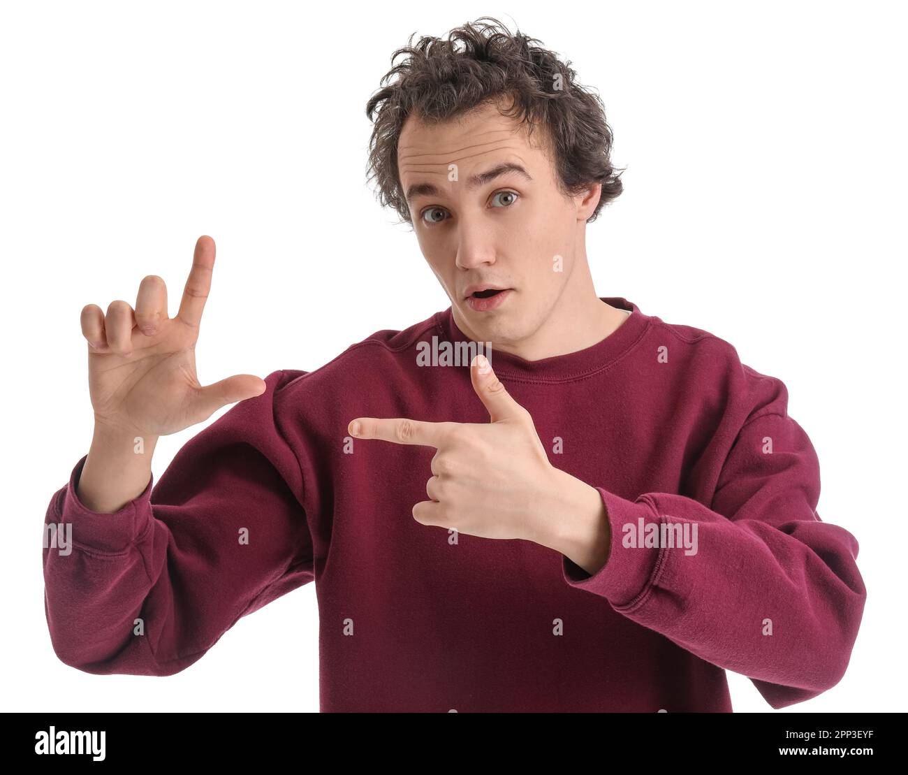Shocked young man showing loser gesture on white background Stock Photo ...