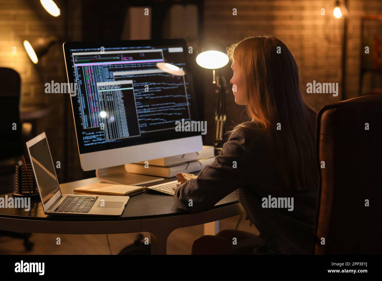 Female programmer working with computer in office at night Stock Photo ...