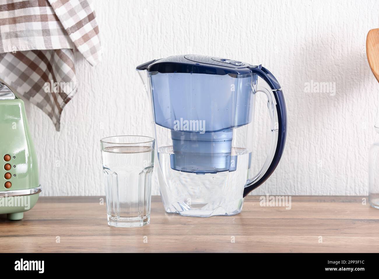Modern filter jug and glass of water on kitchen counter Stock Photo - Alamy