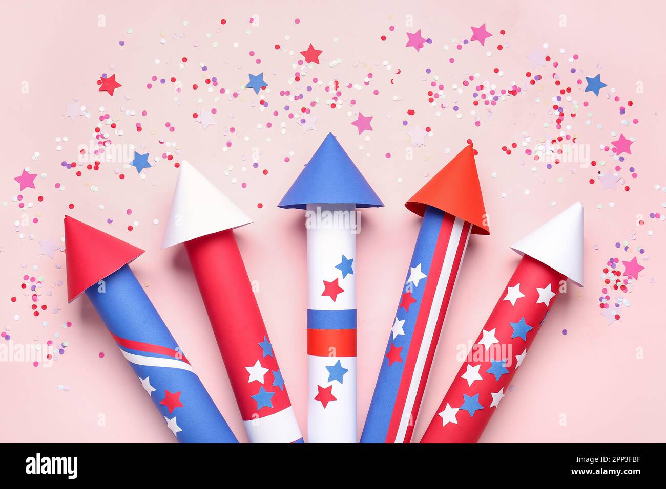 Firework rockets, confetti and serpentine for Independence Day on pink ...