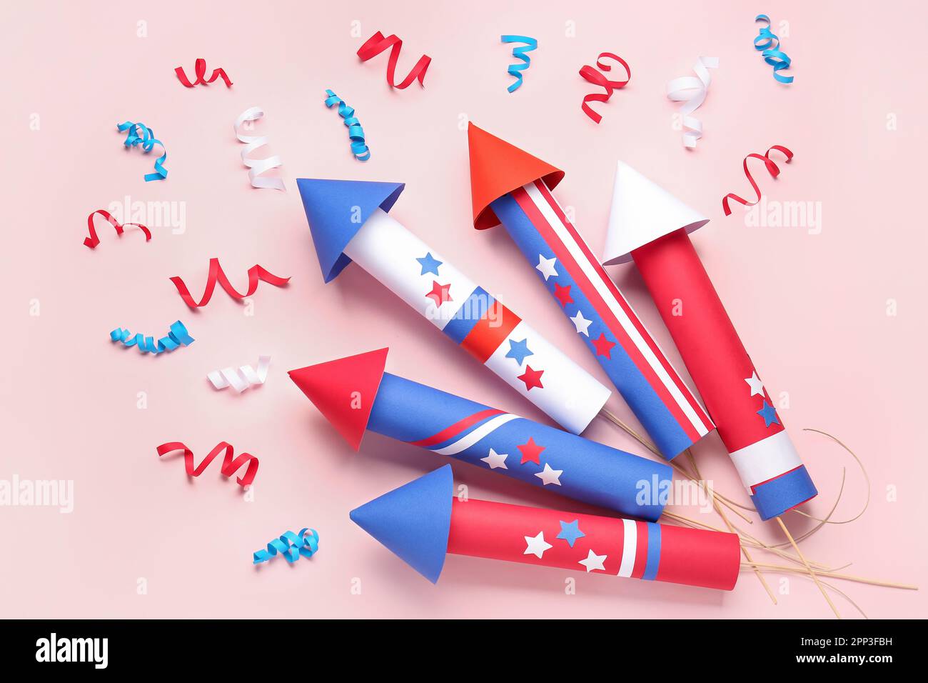 Firework rockets and serpentine for Independence Day on pink background ...