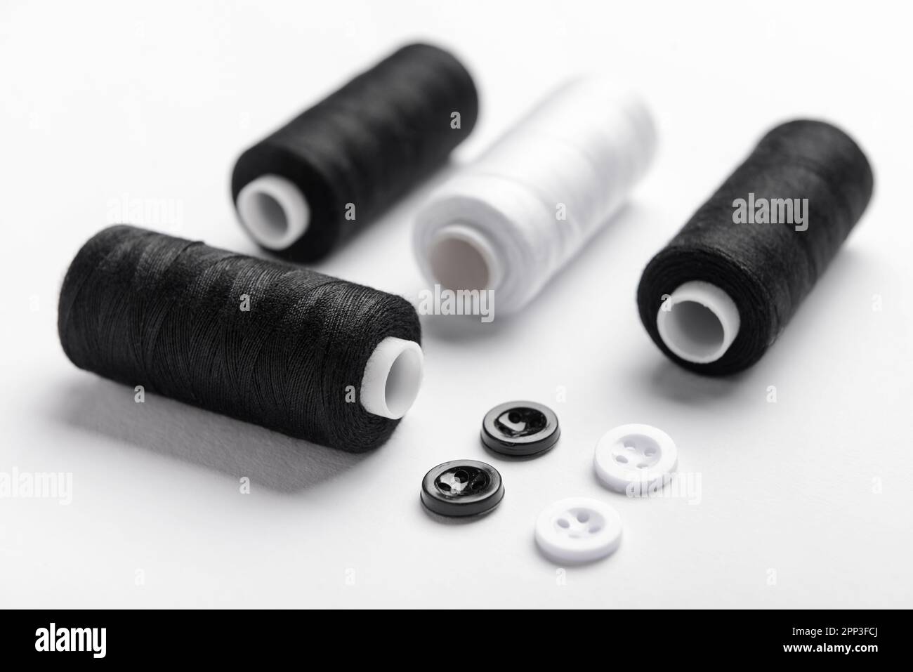 Set of thread spools and buttons on light background Stock Photo - Alamy