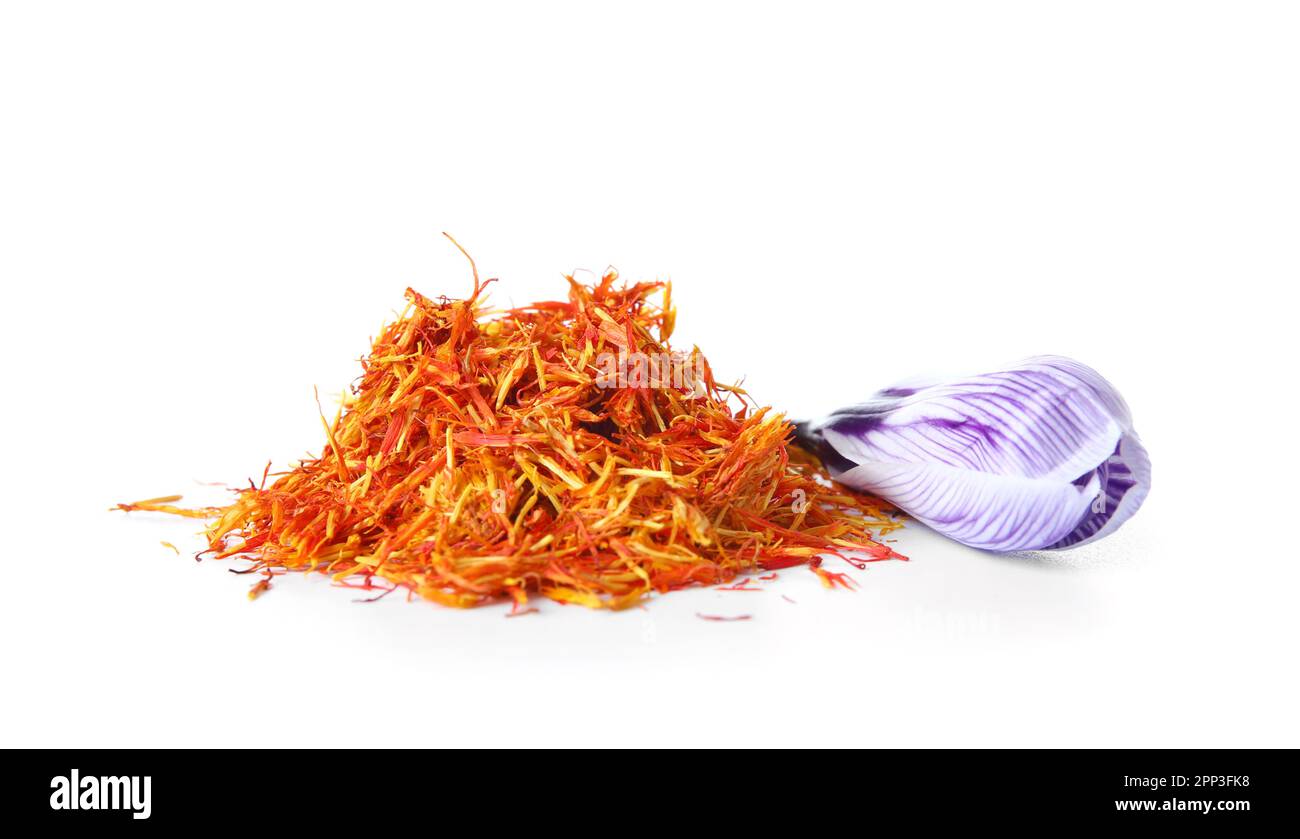 Heap of dried saffron threads and crocus flower isolated on white ...