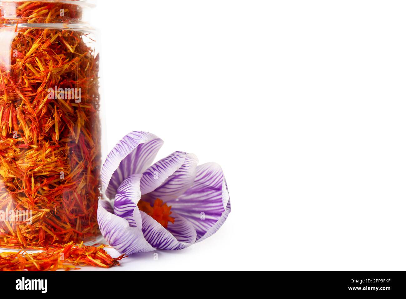 Jar of dried saffron threads and crocus flower isolated on white ...