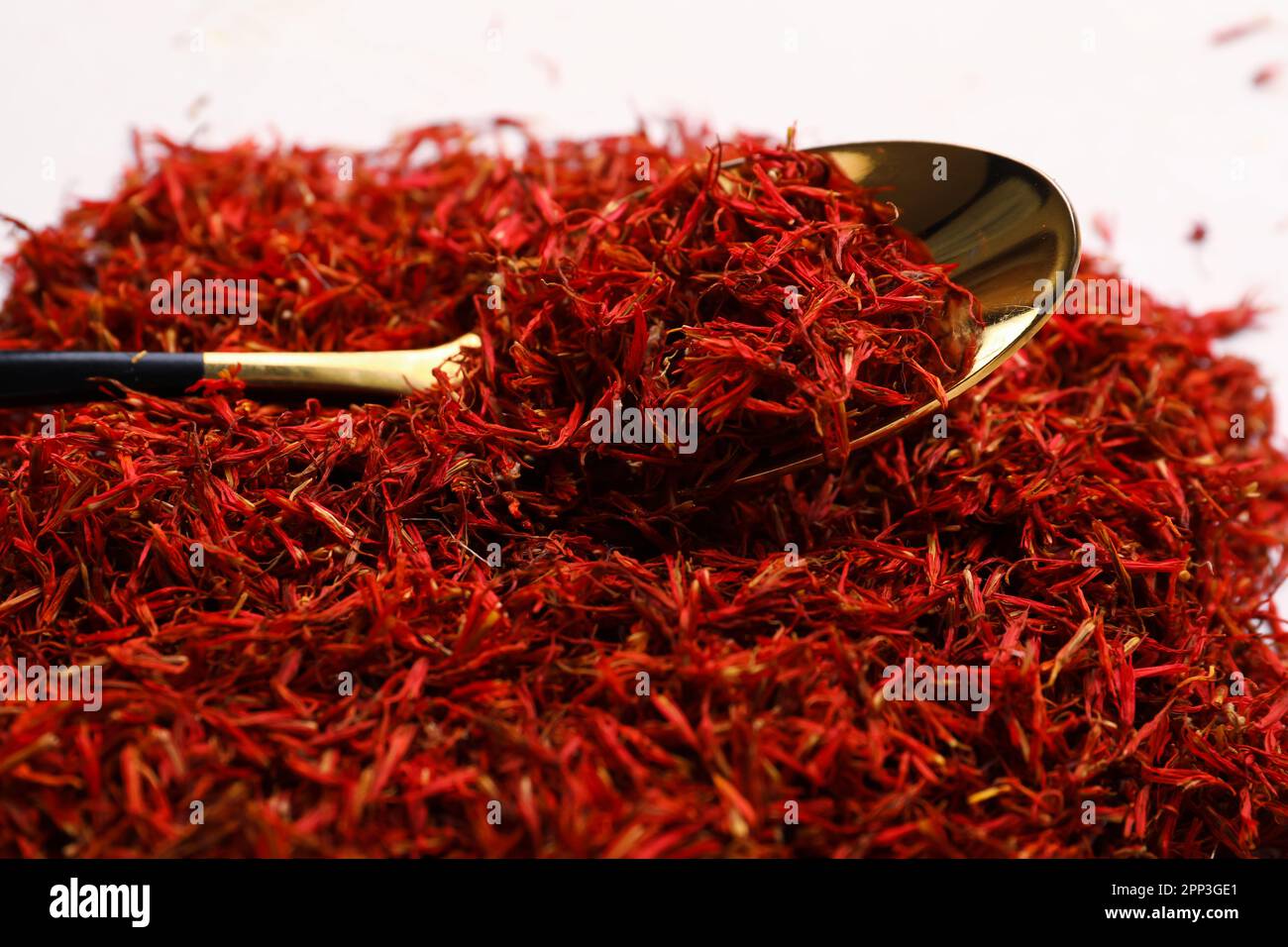 Spoon with pile of saffron on white background Stock Photo - Alamy