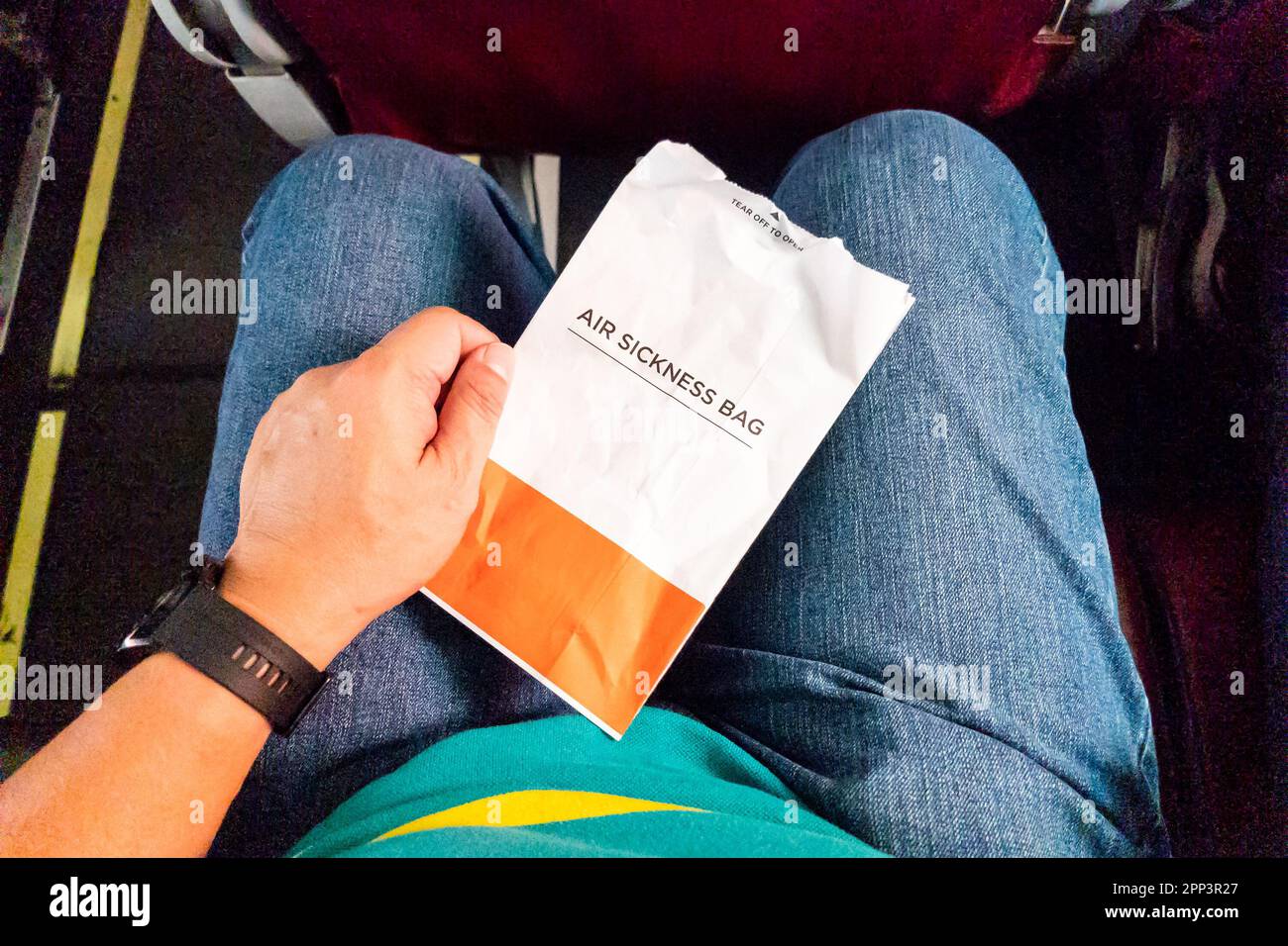 Passanger holding air sickness bag during air flight incase need to ...