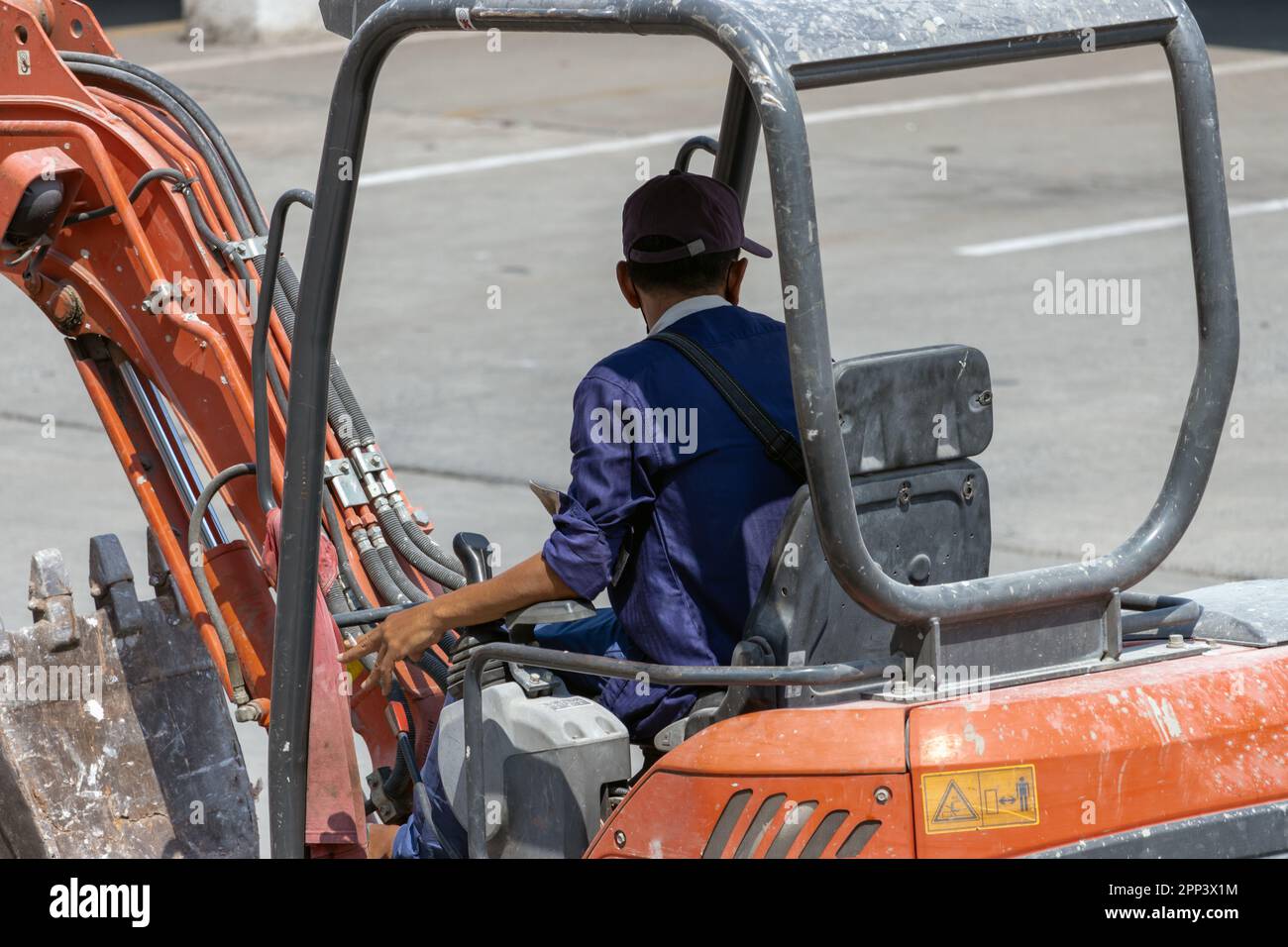 A man drives a digger on the street Stock Photo - Alamy