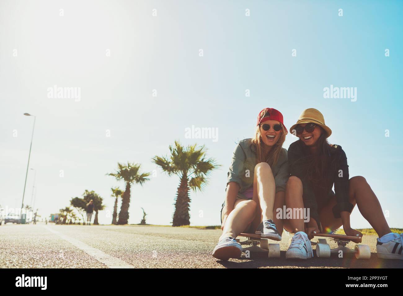 Promenade chilling. two friends hanging out on the boardwalk with a ...