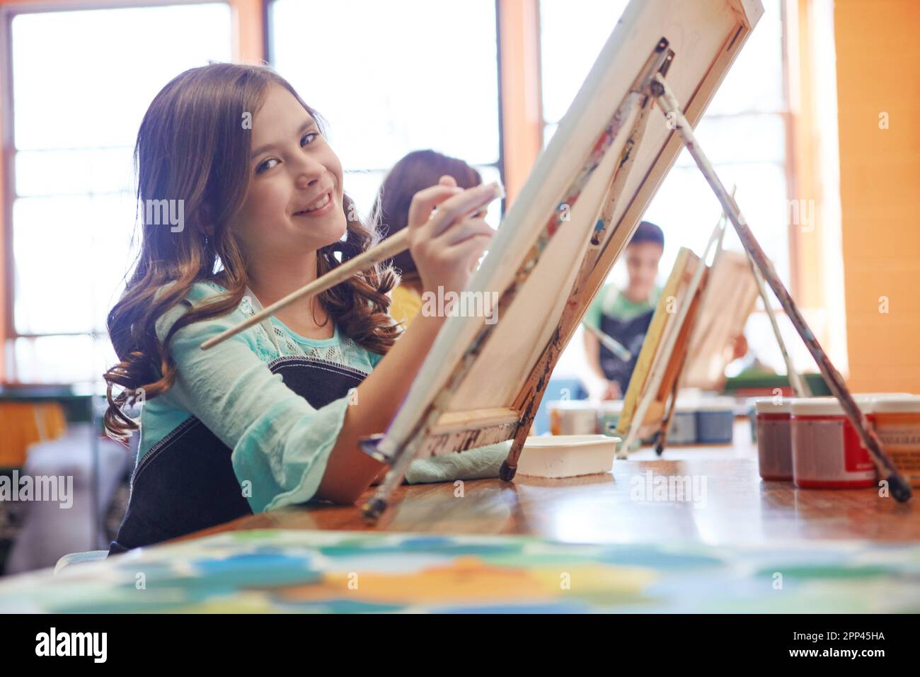 Im happiest behind the canvas. a young schoolgirl in an art class Stock ...