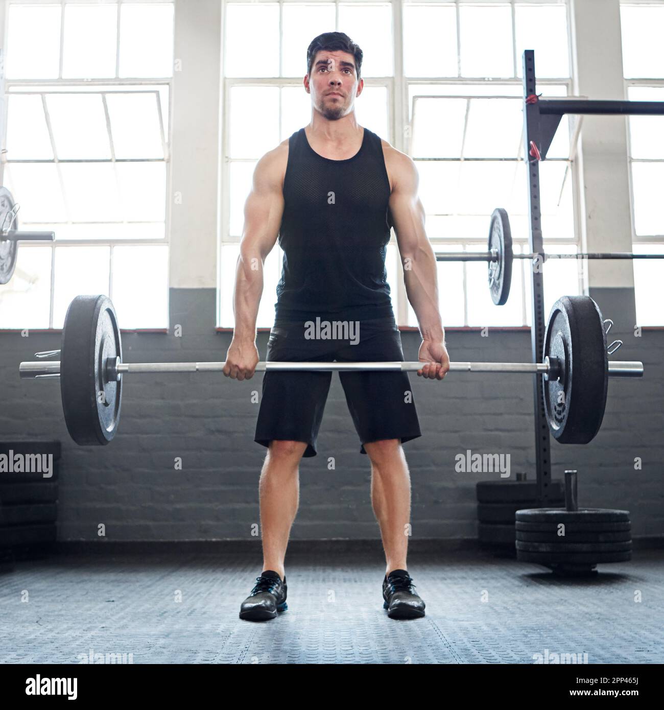 Prepping for the final lift. a young man working out with weights in ...