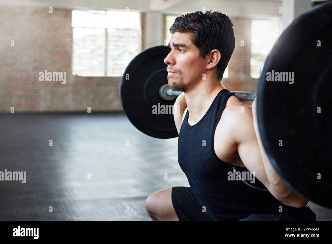 Ready to take this lift to the finish. a young man working out with ...