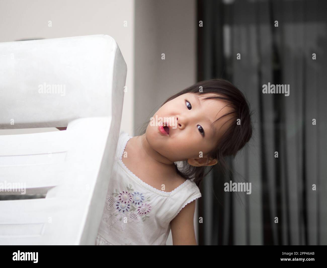 Adorable little girl playing peekaboo, asian child Stock Photo - Alamy
