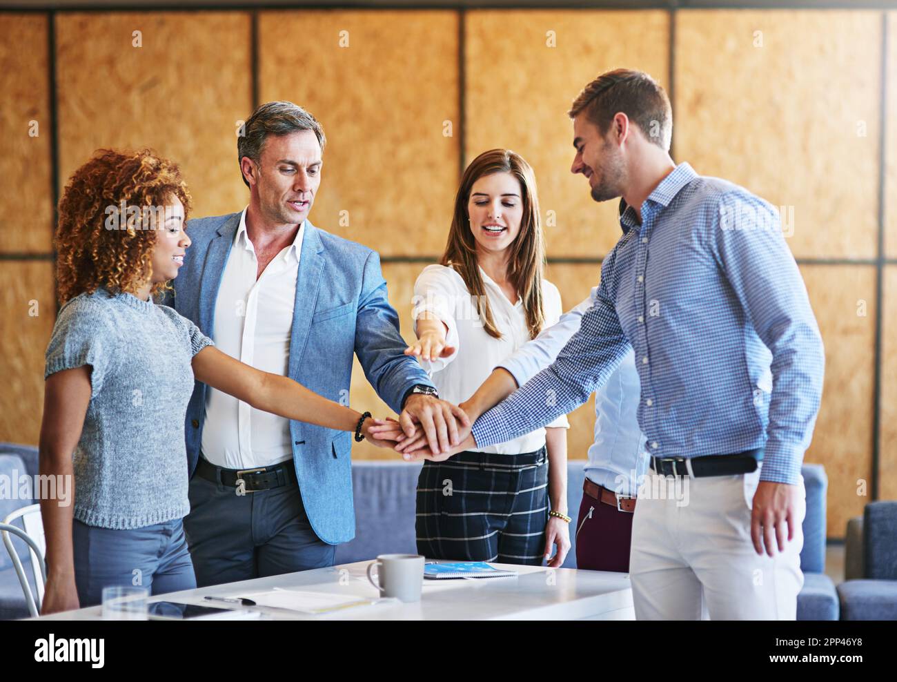 Go team. a group of smiling colleagues huddling together in an office ...