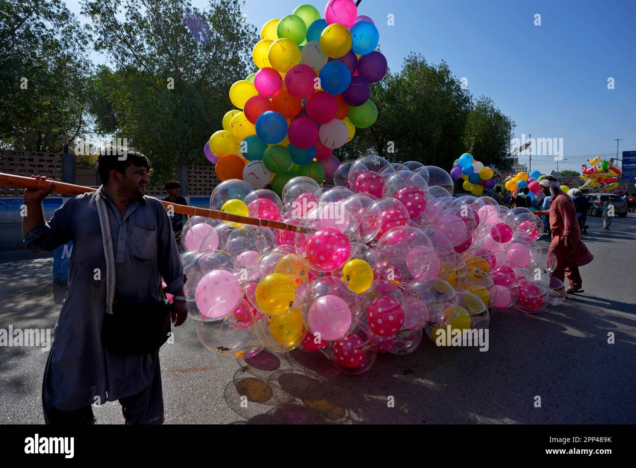 A balloon seller waits for customers outside a ground where people ...