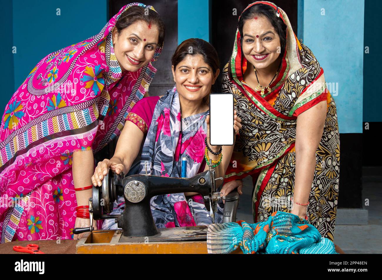 Portrait of three happy traditional indian women wearing sari using ...