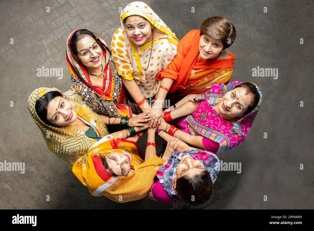 Group of happy young traditional indian women wearing colorful sari ...