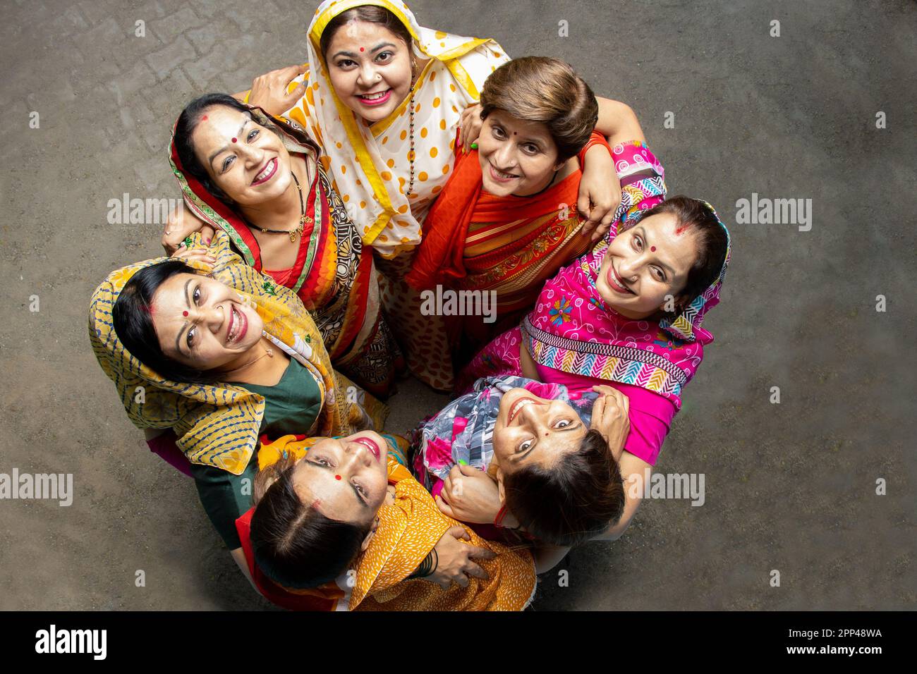 Group of happy young traditional indian women wearing colorful sari ...