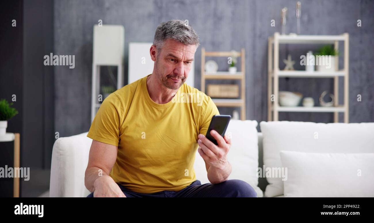 Scam Text Message. Frustrated Confused Man With Phone Stock Photo - Alamy
