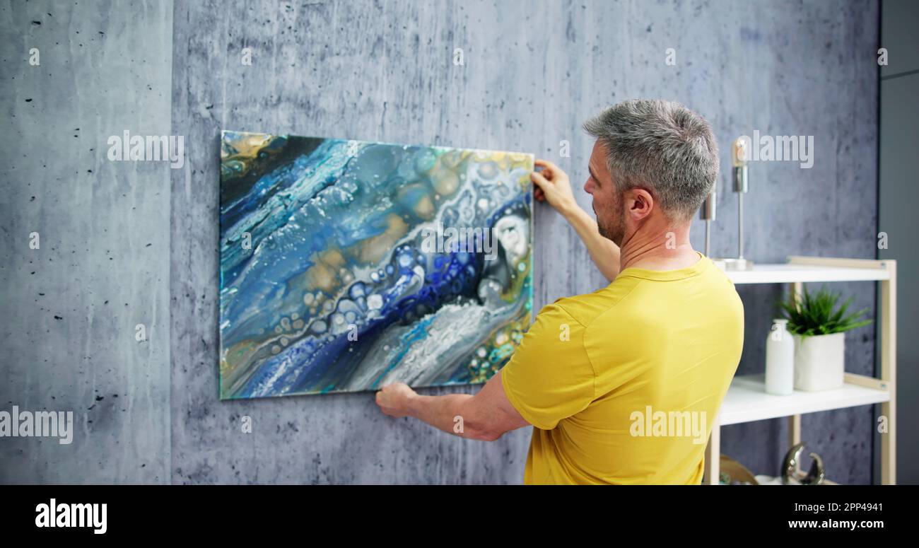 Contemporary Abstract Wall Painting Decoration. Man Hanging Picture ...