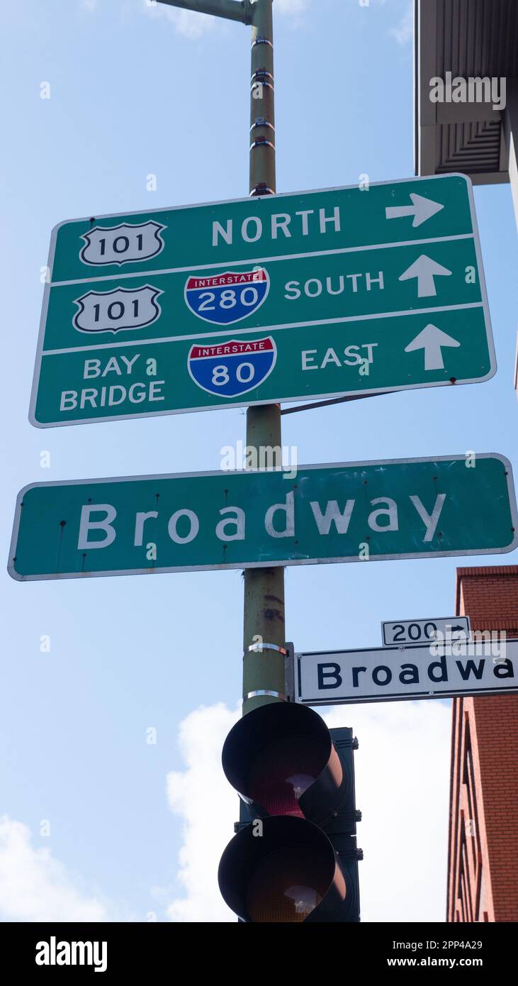 Traffic light and Broadway Bay bridge road signs with direction ...