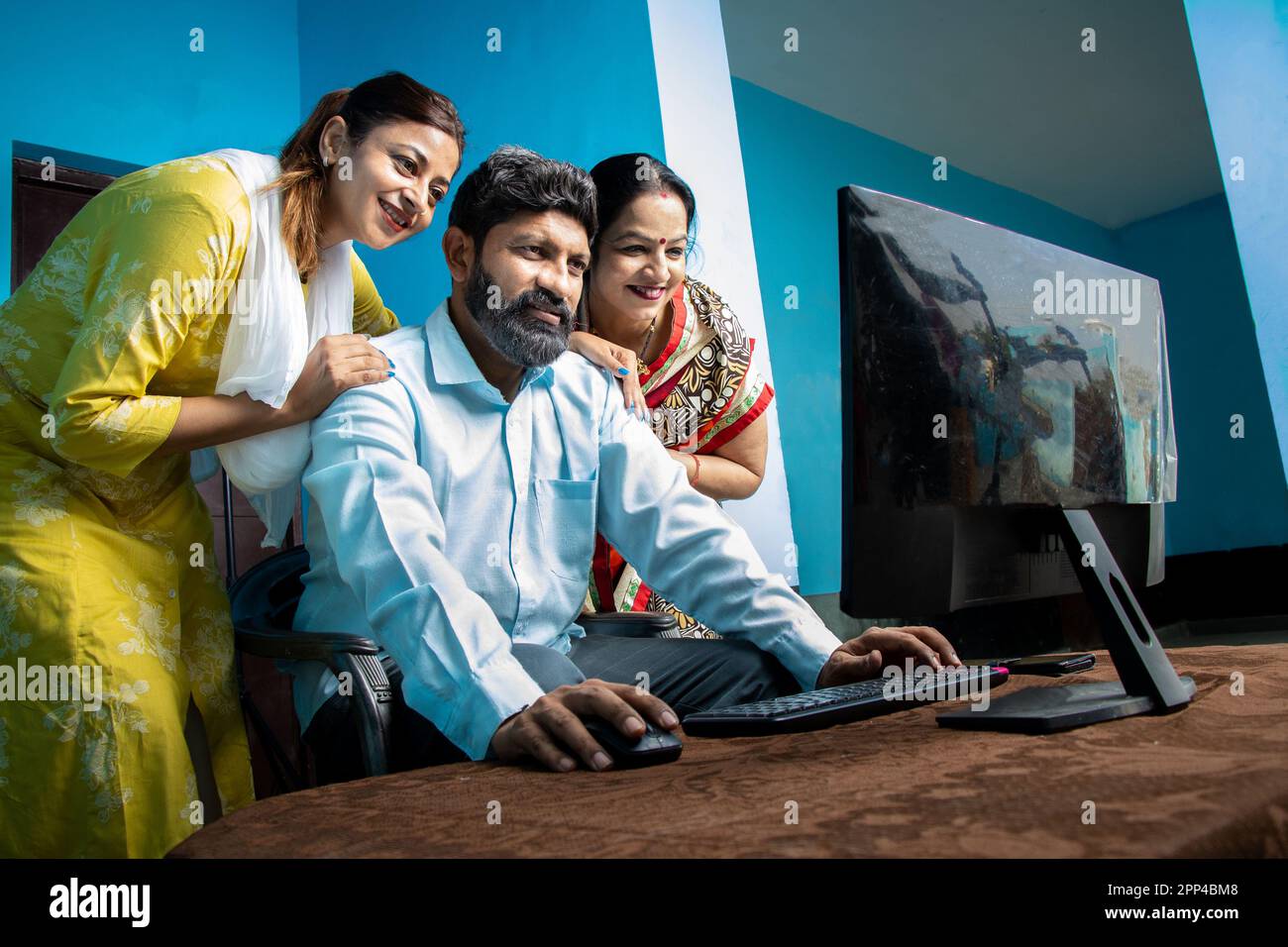Traditional indian Man with his wife and daughter using computer. Learn ...