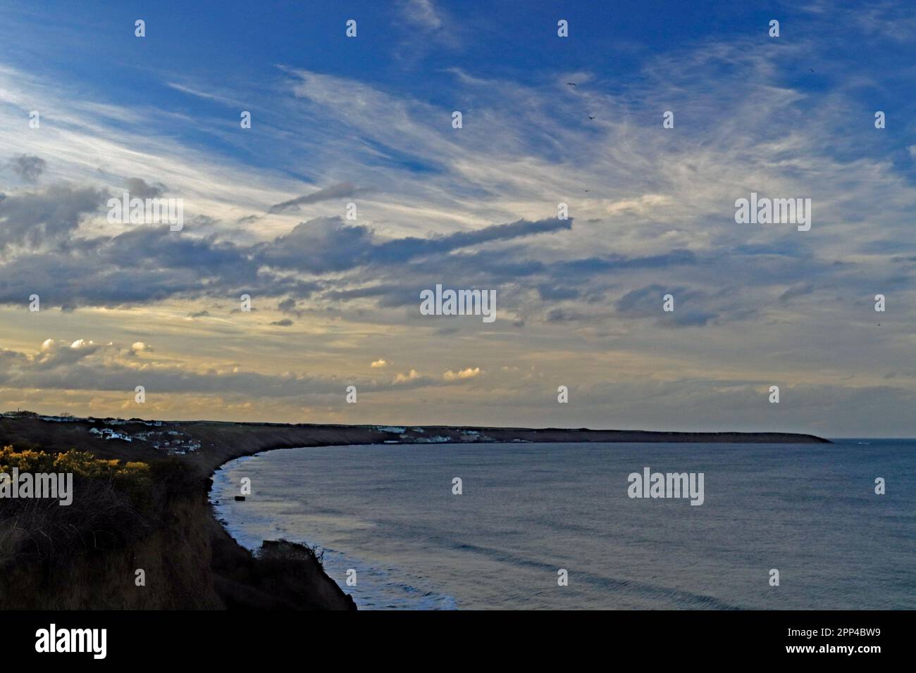 Hunmanby Bay on a spring evening under a big blue sky and white clouds ...